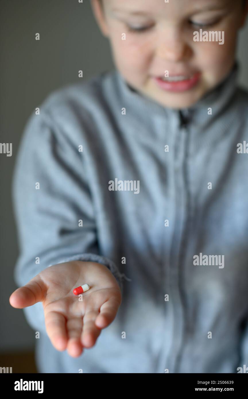 kid is going to take a pill of supplement Stock Photo - Alamy