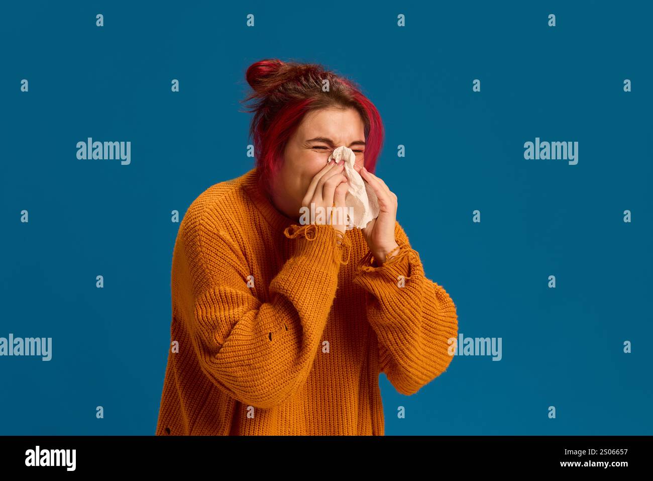 Woman sneezing into tissue, indicating runny nose and infection-related ...