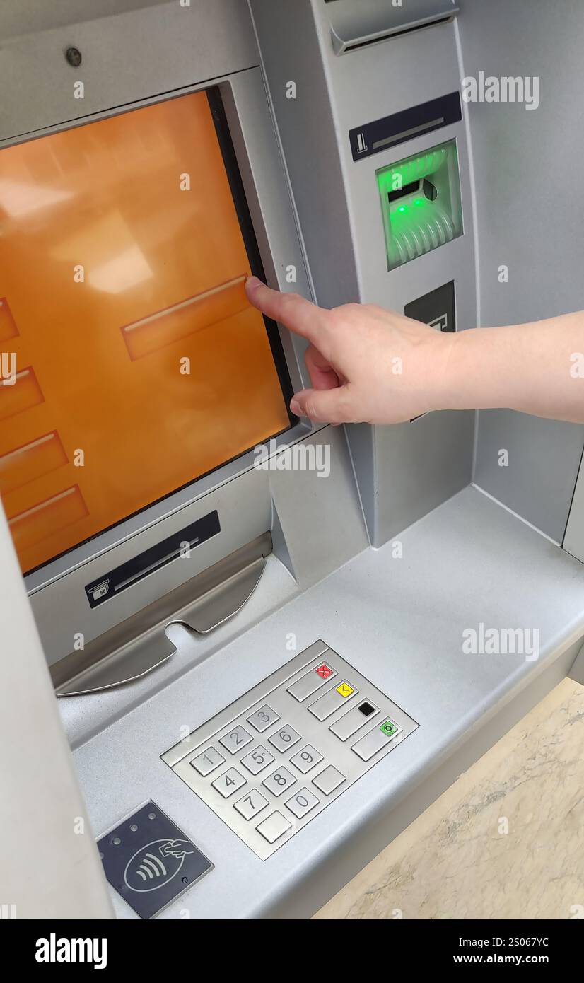 A confident hand navigates the ATM screen, managing transactions with ...