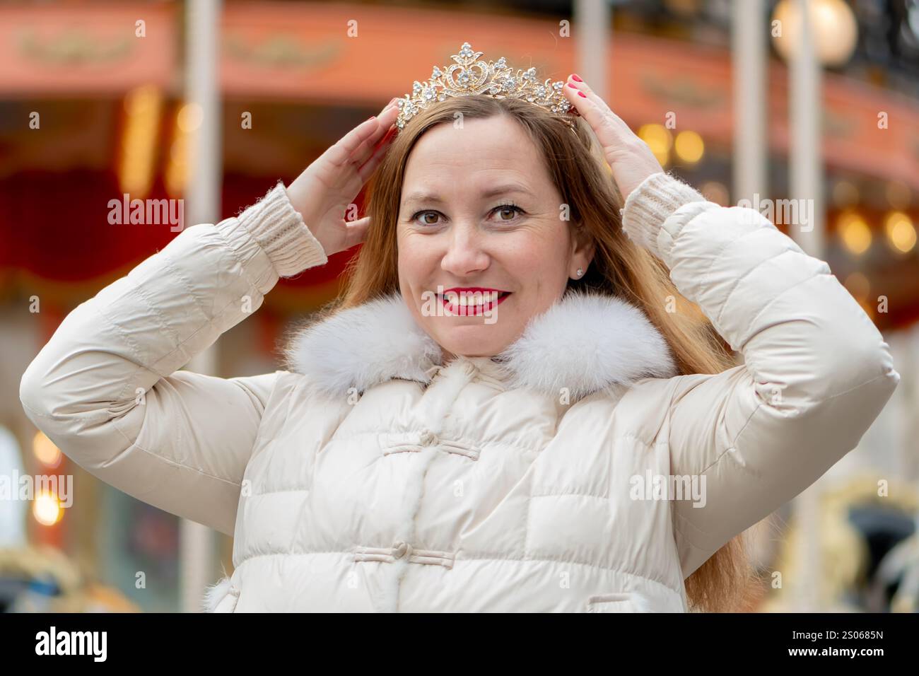 A beautiful woman tries on a crown on her head among a crowd of people ...