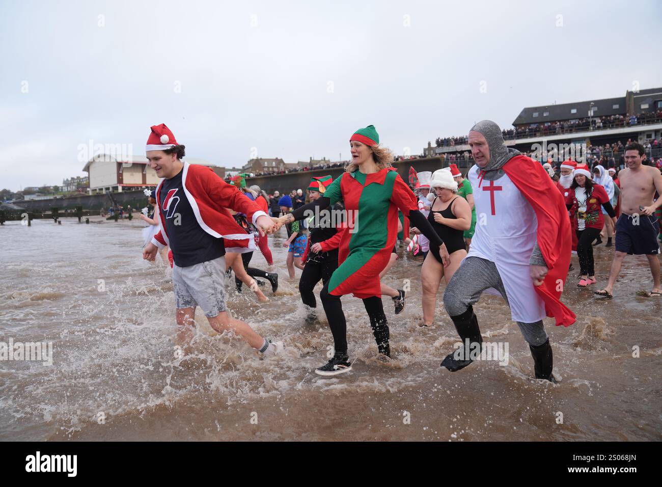 People take part in a Christmas Day dip at Hunstanton in Norfolk ...