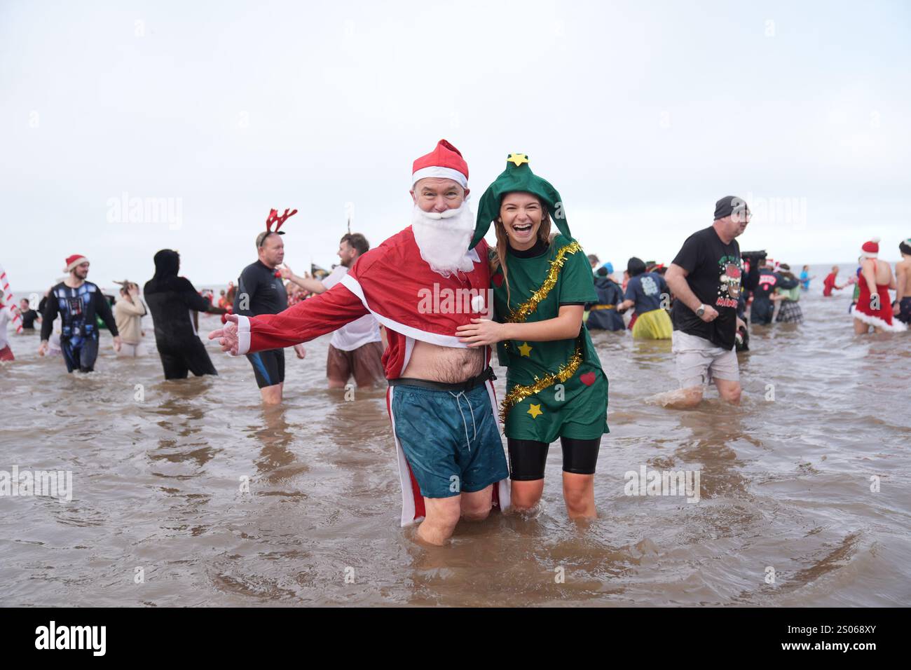 People take part in a Christmas Day dip at Hunstanton in Norfolk ...