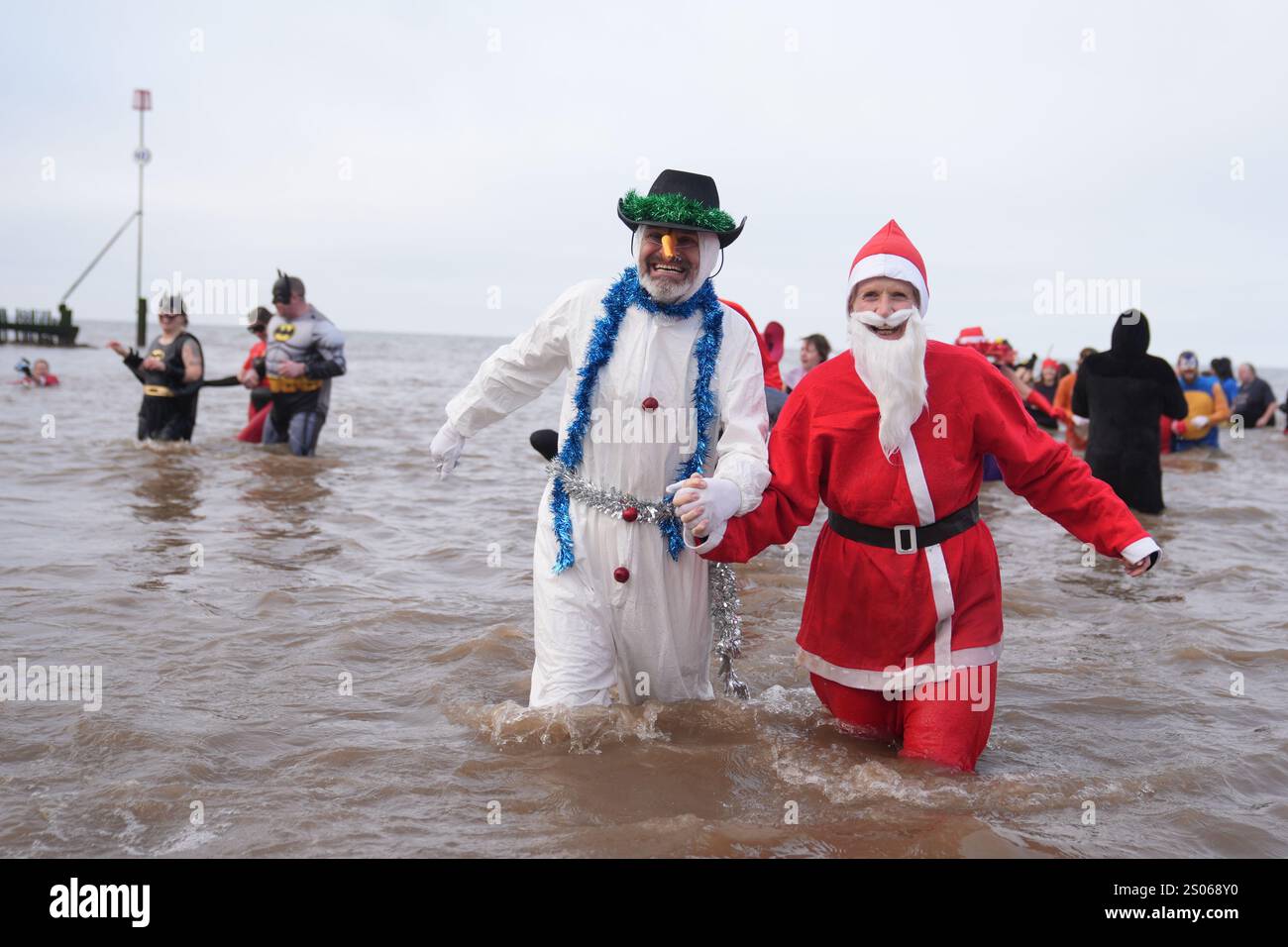 People take part in a Christmas Day dip at Hunstanton in Norfolk ...