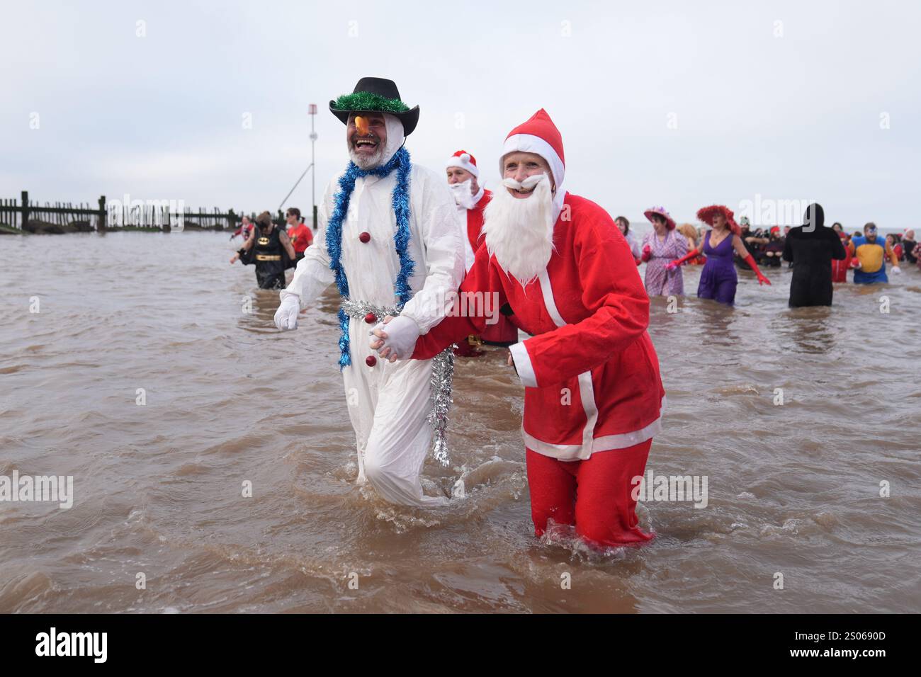 People take part in a Christmas Day dip at Hunstanton in Norfolk ...