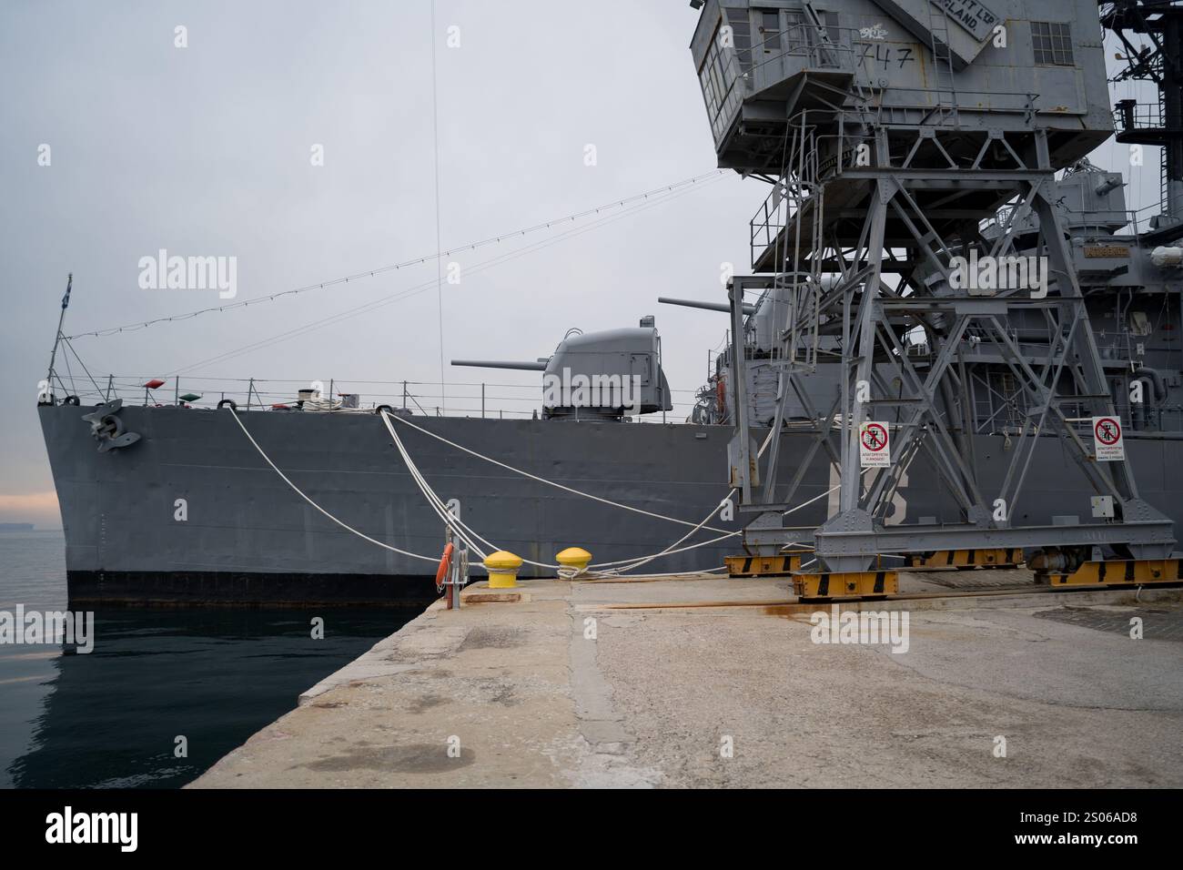Nose of British warship with gun cannon moored to the coast in ...