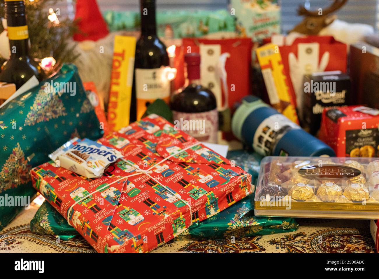 A Christmas Day table laden with gifts, chocolates, cake, and drinks ...