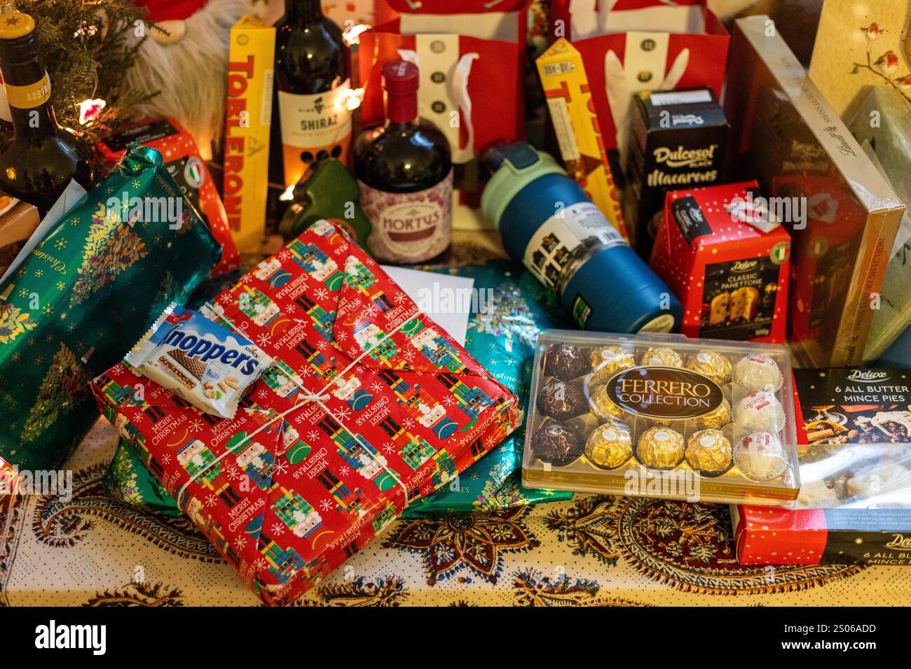 A Christmas Day table laden with gifts, chocolates, cake, and drinks ...
