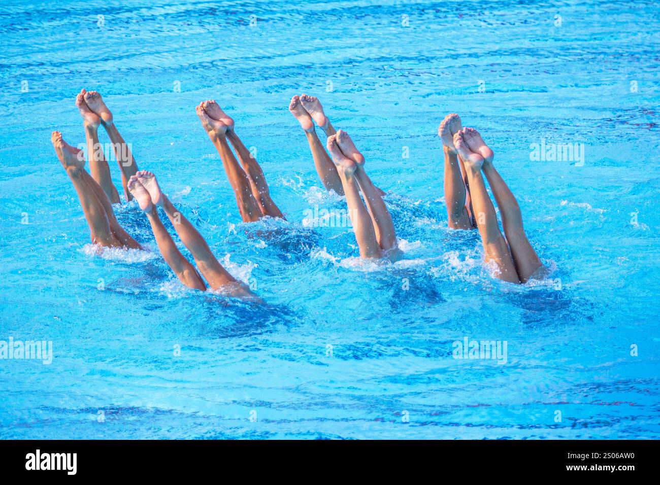 Artistic swimmers team performing synchronized legs choreographed ...