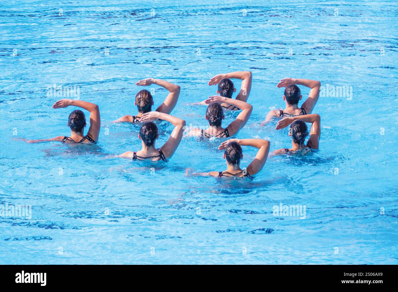 Artistic swimmers team performing synchronized choreographed routine in ...