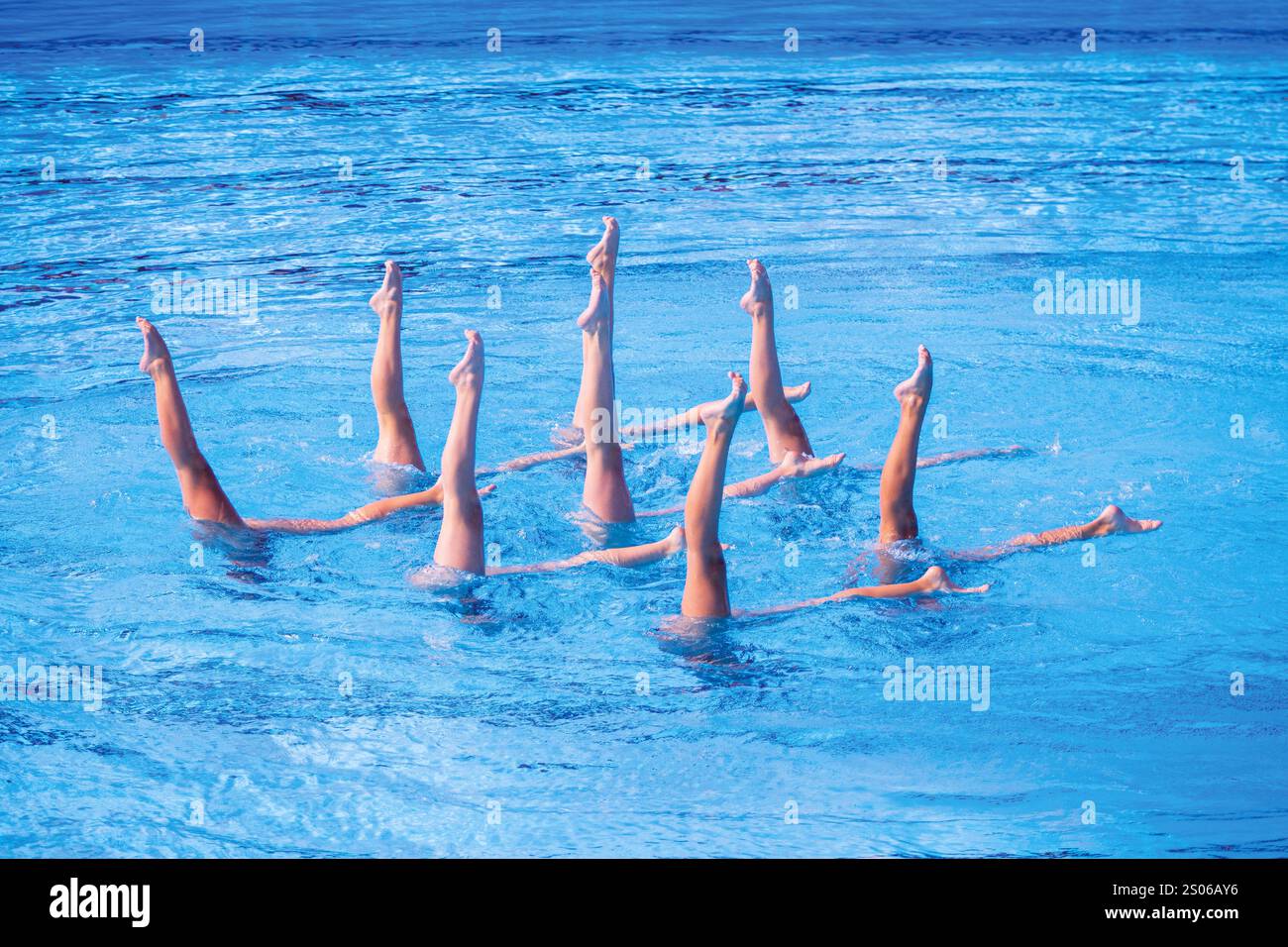 Artistic swimmers team performing synchronized legs choreographed ...