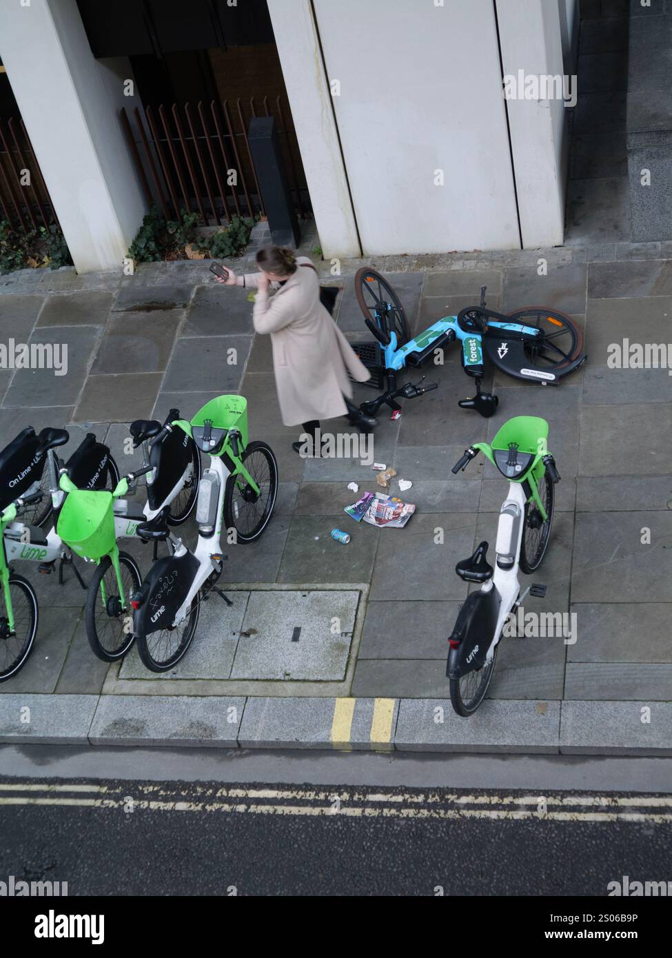 A pedestrian in the City of London, UK, navigates through discarded ...