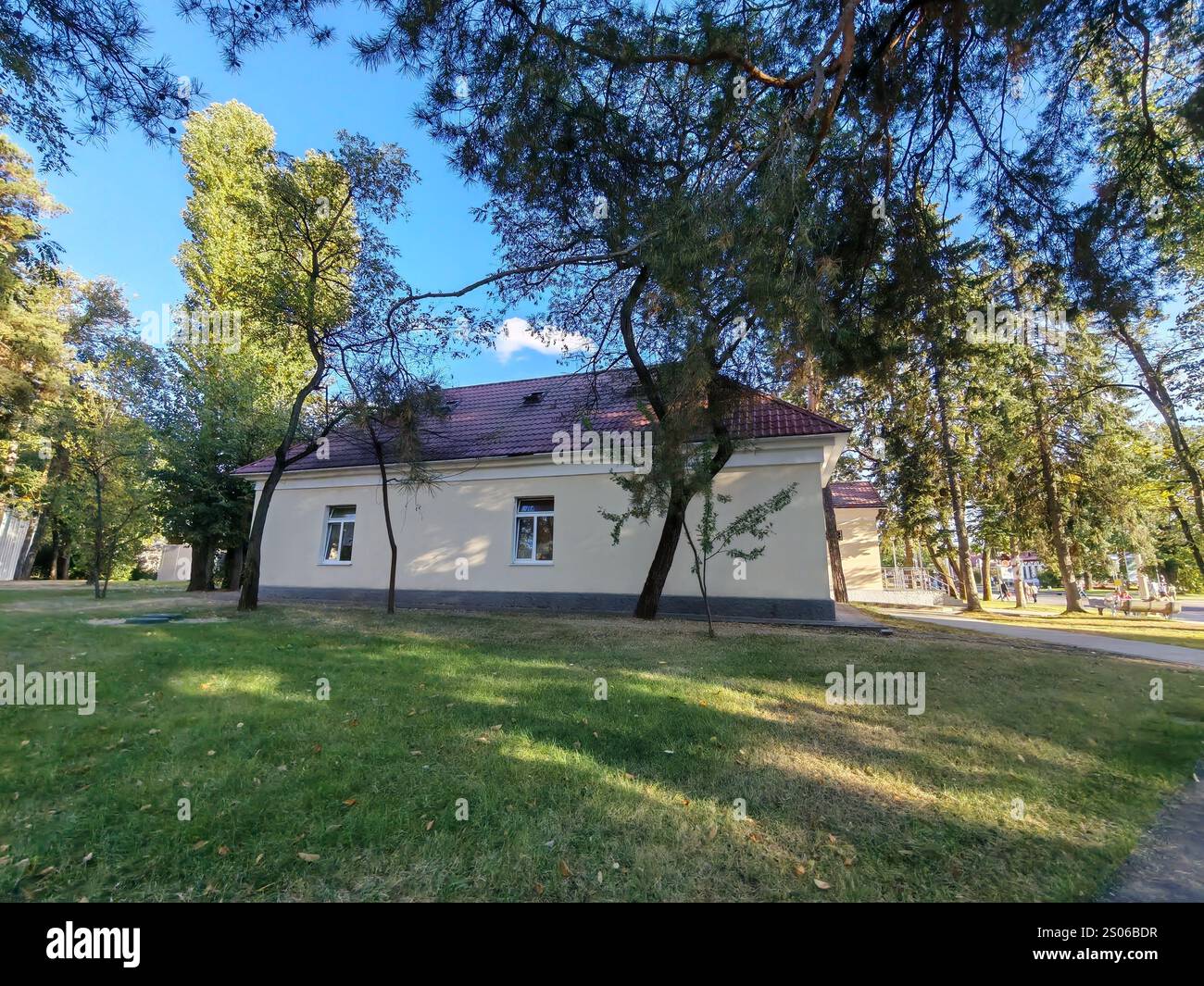 A traditional building with red accents and a tall, sloped roof, framed ...