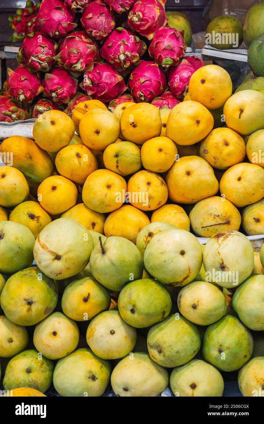 A colorful fruit display case made of mangoes and dragon fruit on ...