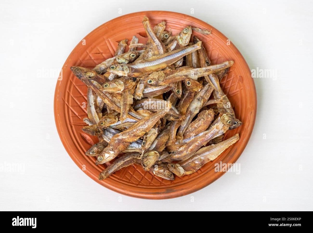 Dried anchovy fish (Mola Shutki in Bangladesh) on a clay plate ...