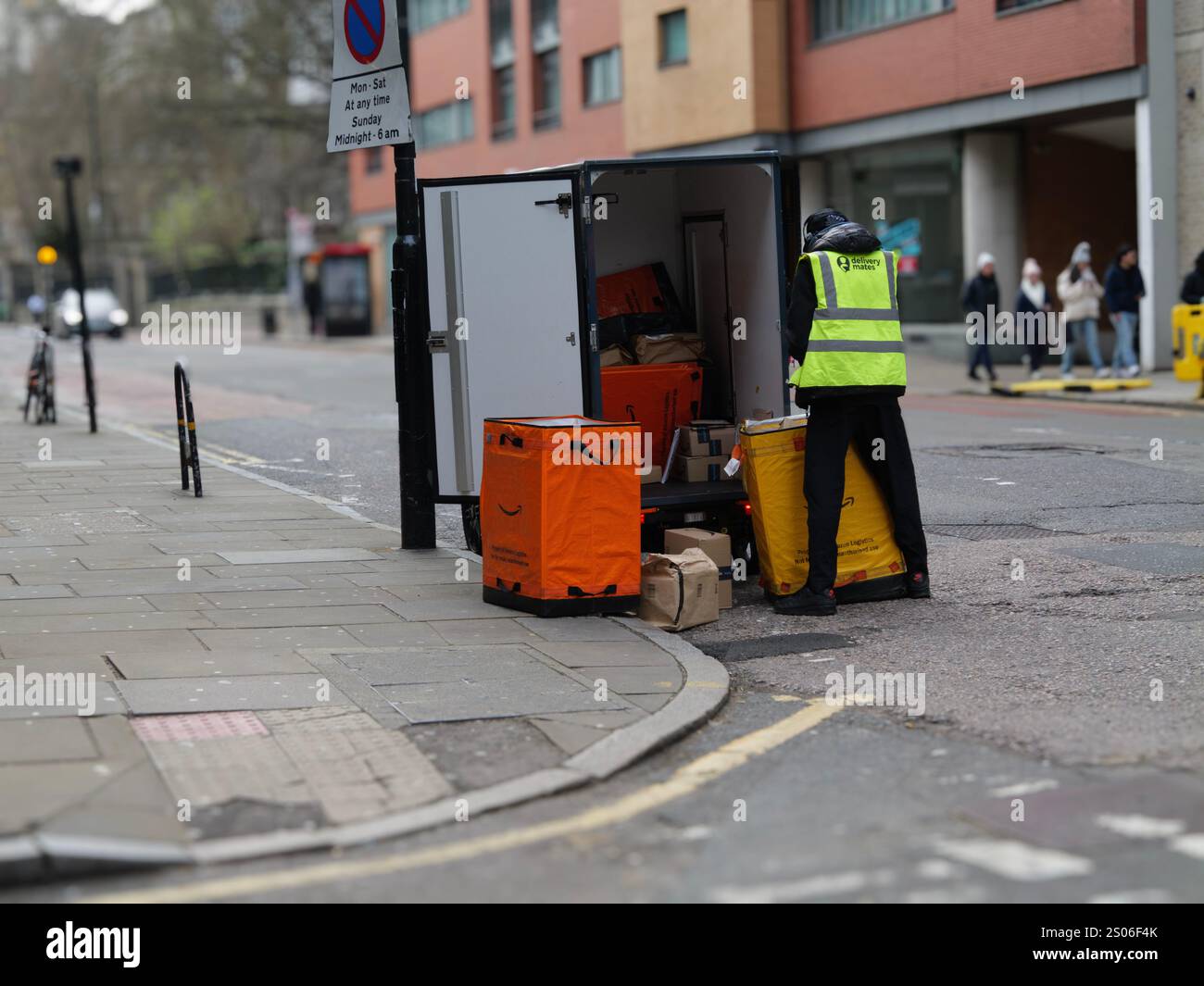 A driver unloading parcels from an Amazon Mubea electric cargo bike on ...