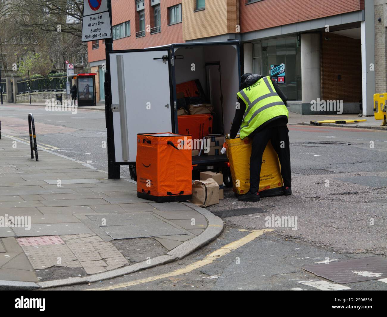 A driver unloading parcels from an Amazon Mubea electric cargo bike on ...