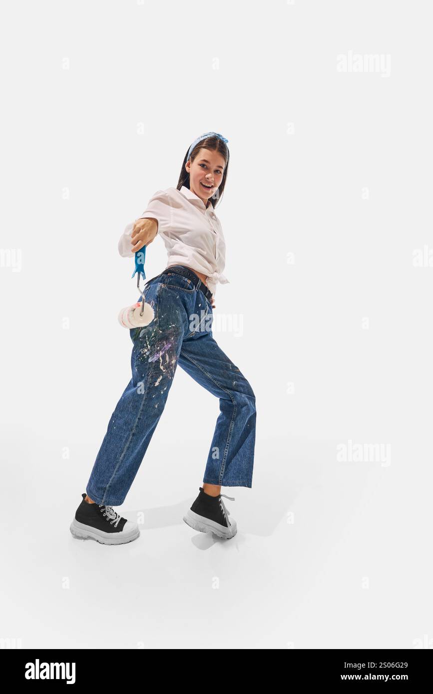 Painter in white shirt and colorful jeans leaning backward, raising ...