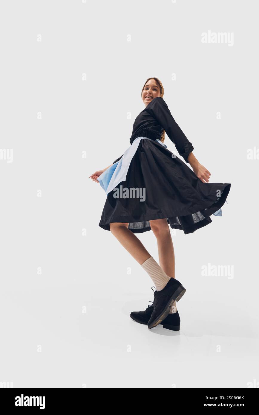 Female waiter in black outfit taking step back while looking dynamic ...