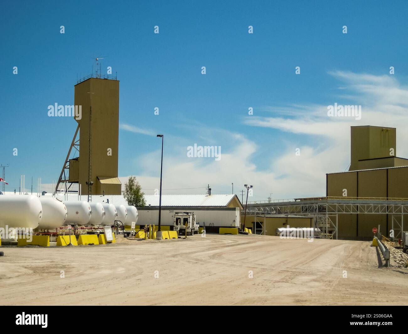 A large industrial area with a lot of white tanks and a large building ...