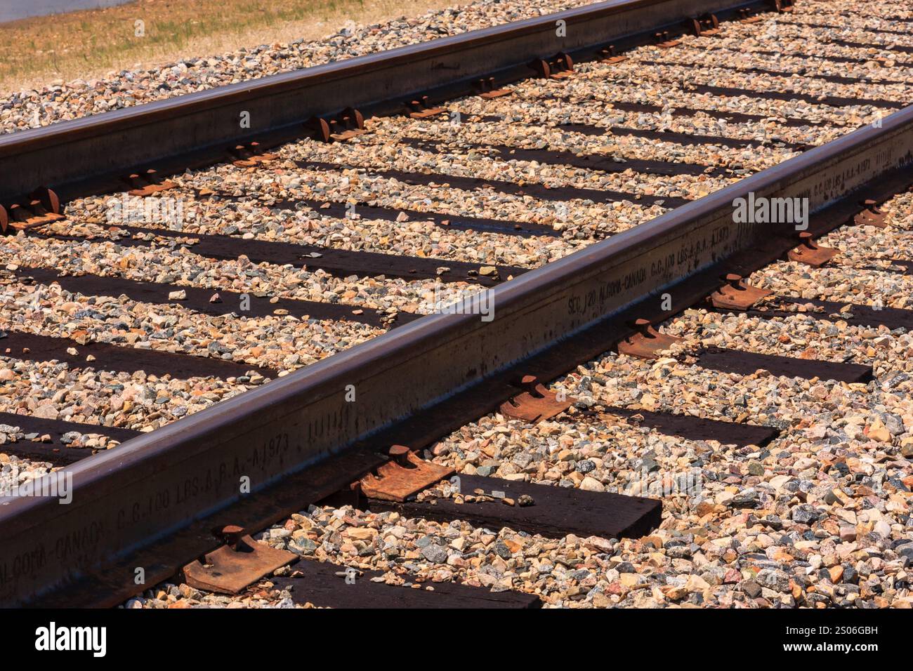 The train tracks are covered in gravel and rocks. The tracks are old ...