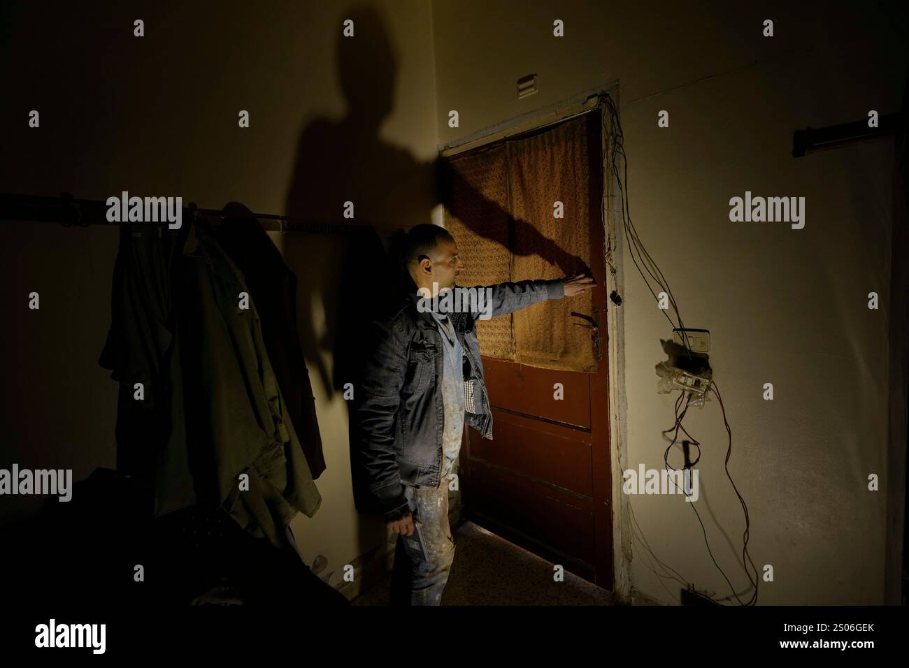 Hussein Arbeeni, 41, shows how he blocked a room door by tapes where 23 ...