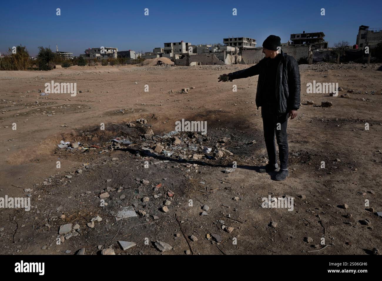 Hassan Arbeeni, 42, shows a crater where a surface-to-surface missile ...