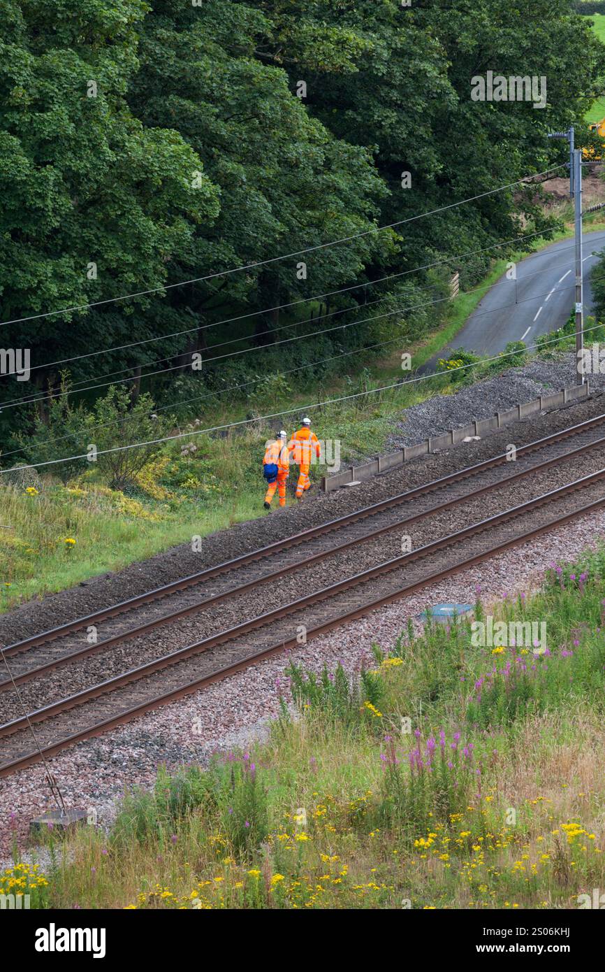 Network Rail workers walking alongside the west coast mainline to get ...