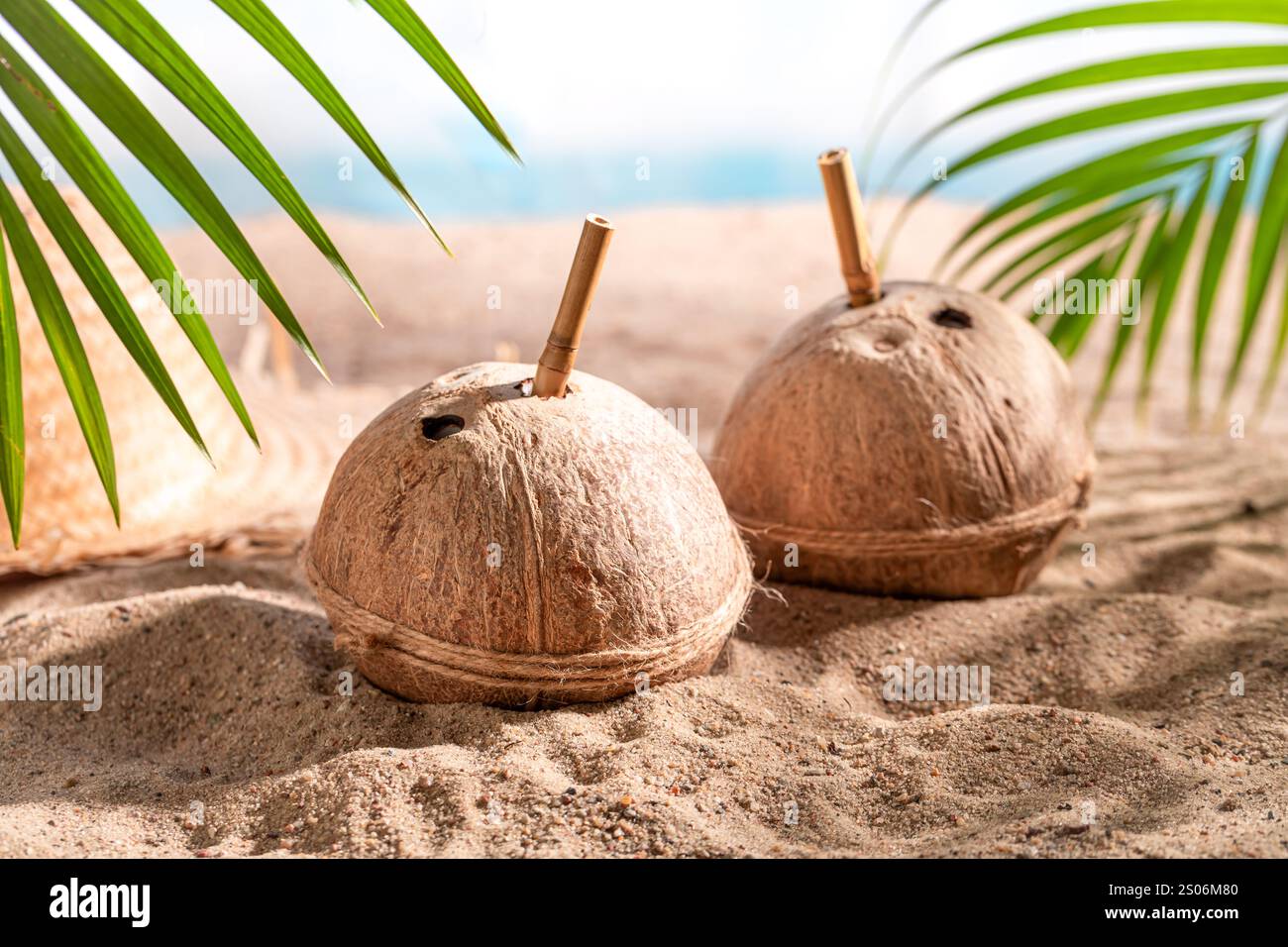 Healthy coconut milk in shell ready to drink. Drink served on an exotic ...