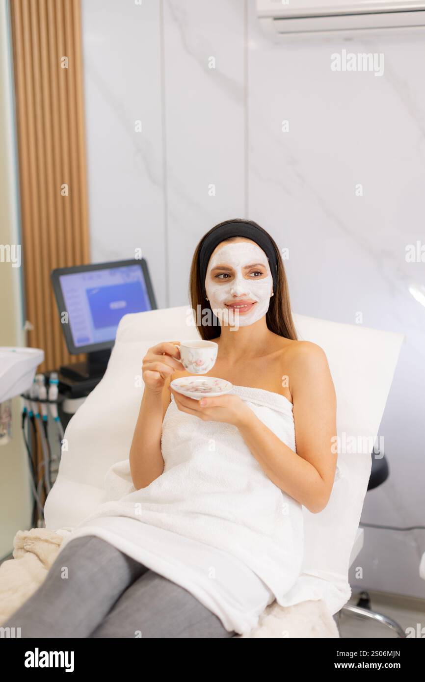 Relaxation fills the air as a woman in a spa setting sips herbal tea ...