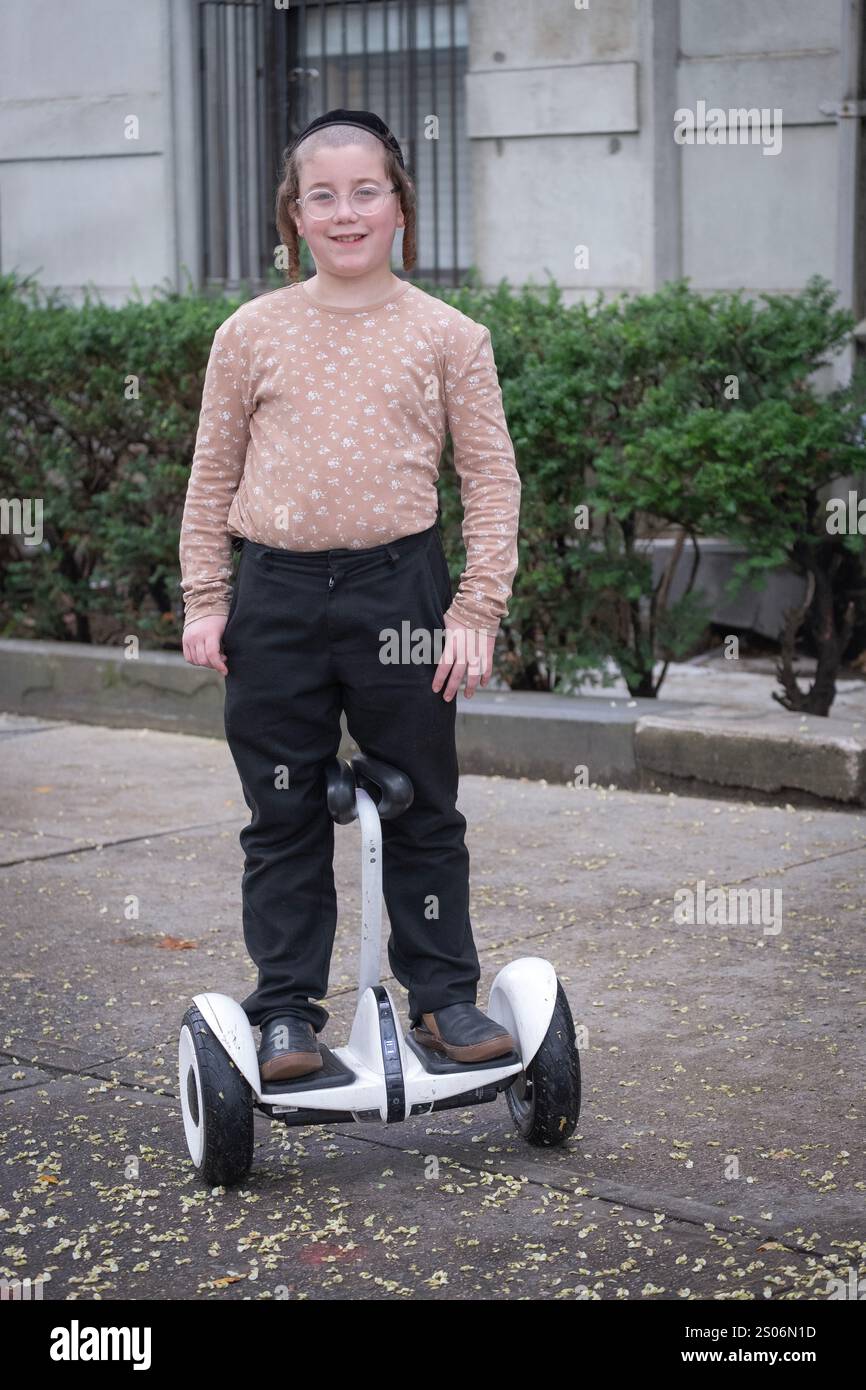 An orthodox Jewish teenager poses for a photo on his hover board. On ...