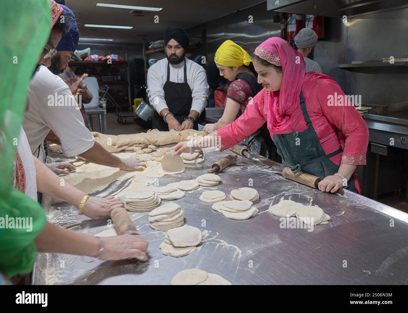 Sikh men & women of various ages make roti breads in a langar, free ...