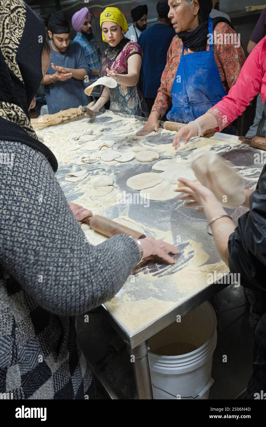 THE TOSS Volunteers in a Sikh temple langar kitchen prepare roti breads ...
