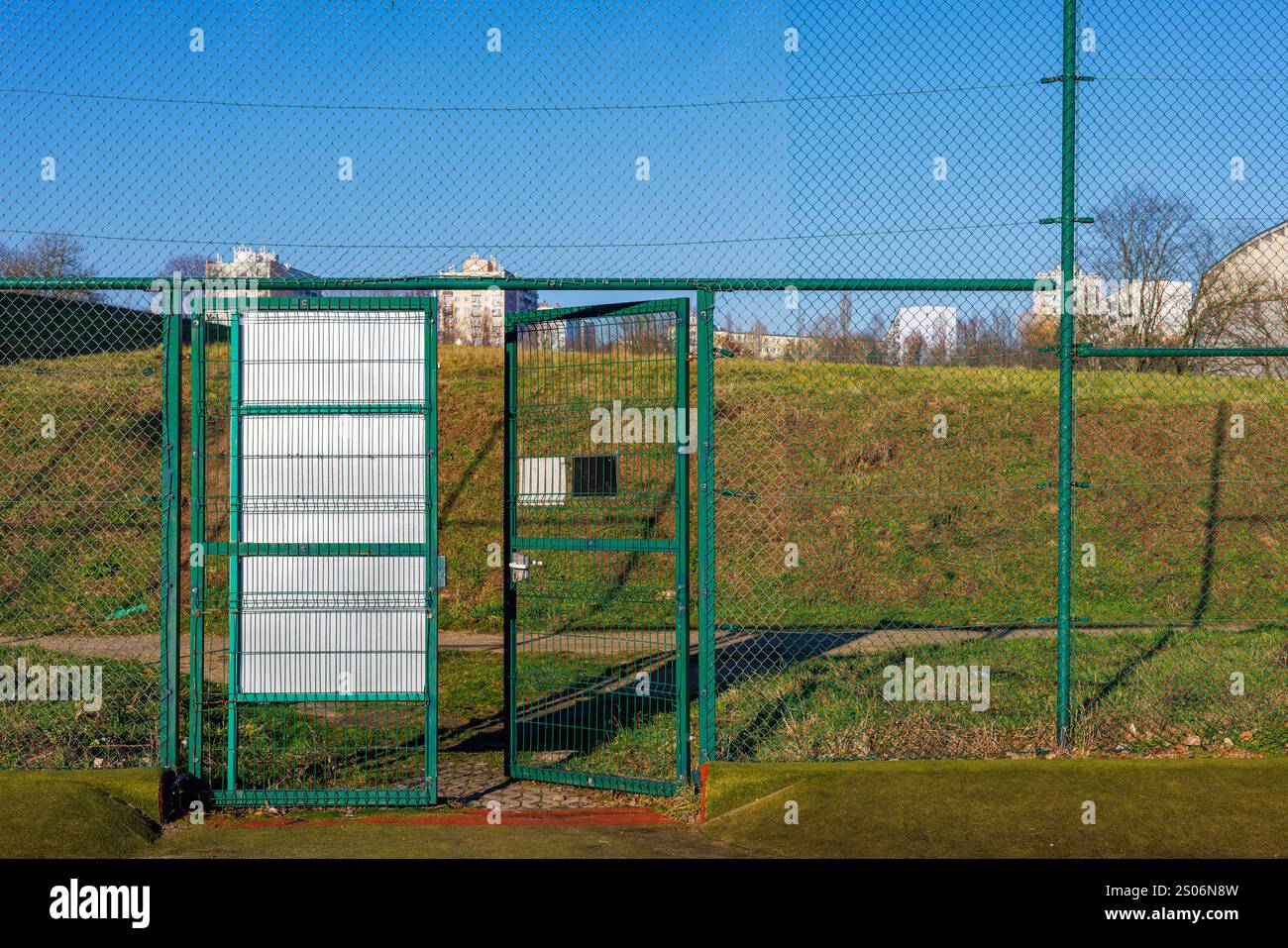 Open gate in the high fence of the children's playground, football ...