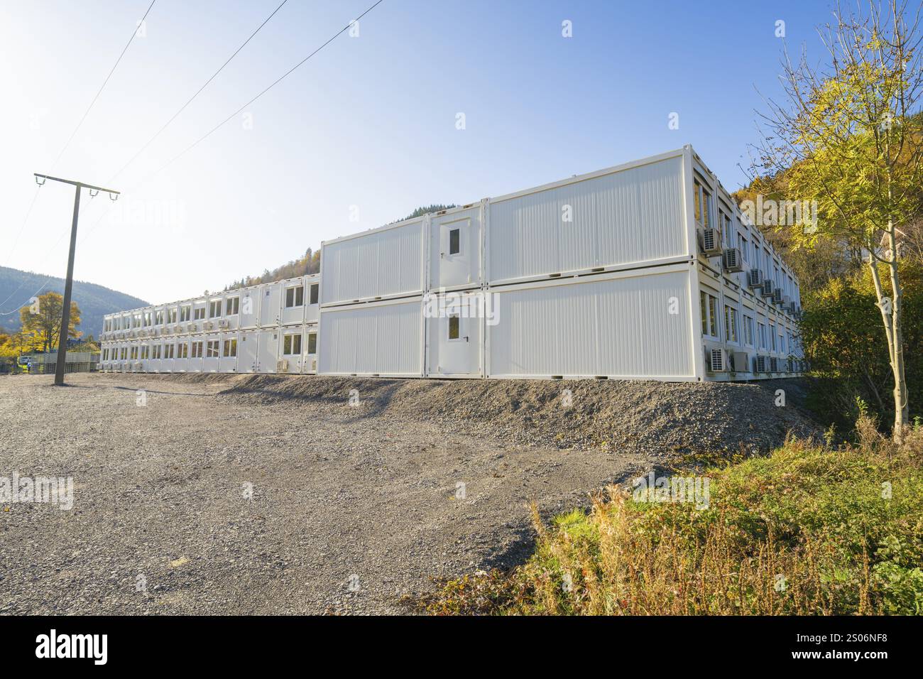 Container building in nature on gravelly ground with blue sky and ...