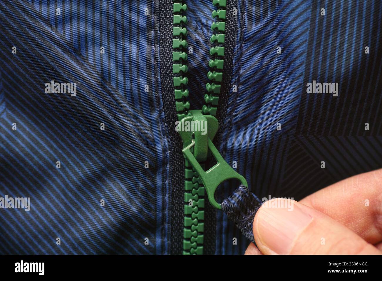 A person unzipping a blue jacket Stock Photo - Alamy