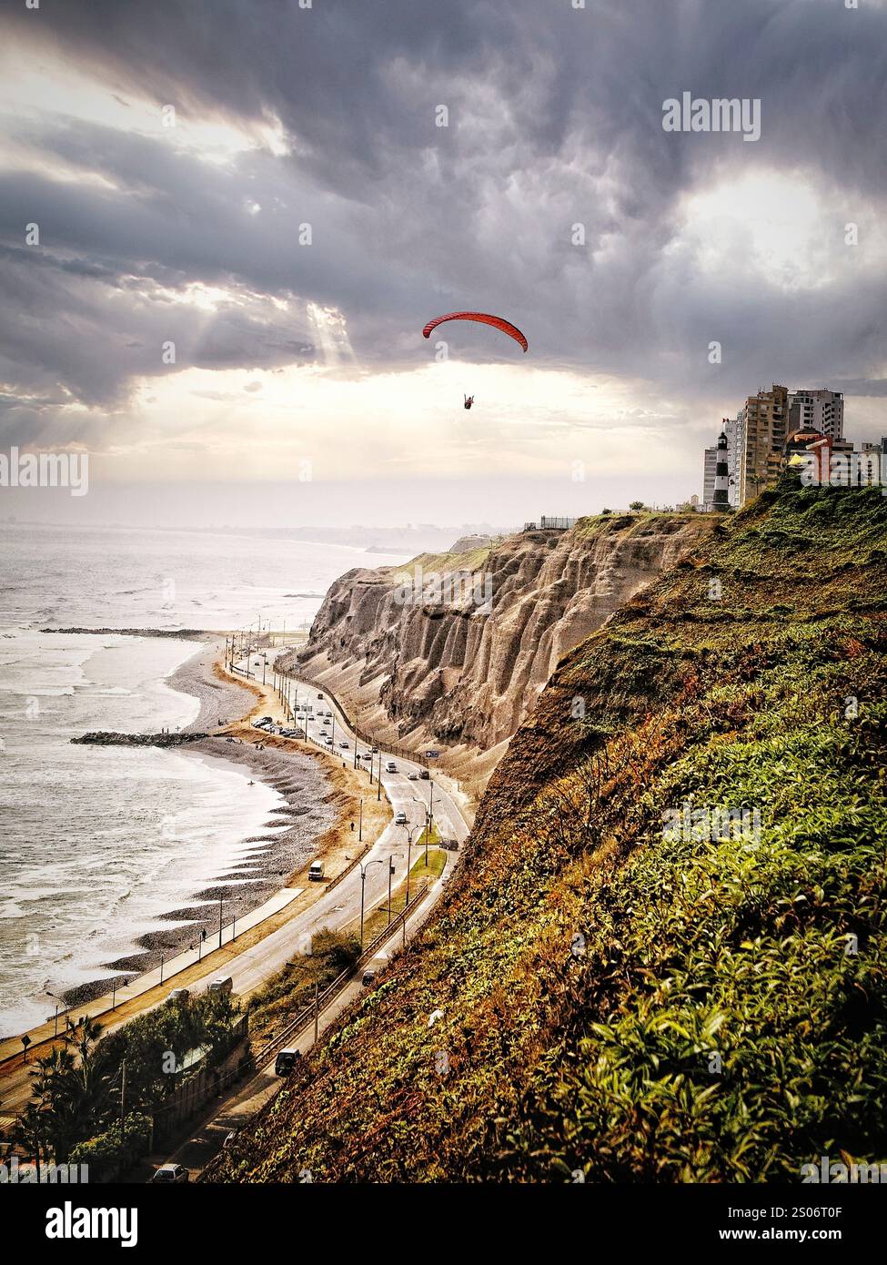 A hang glider soars gracefully along the dramatic coastline of Lima ...