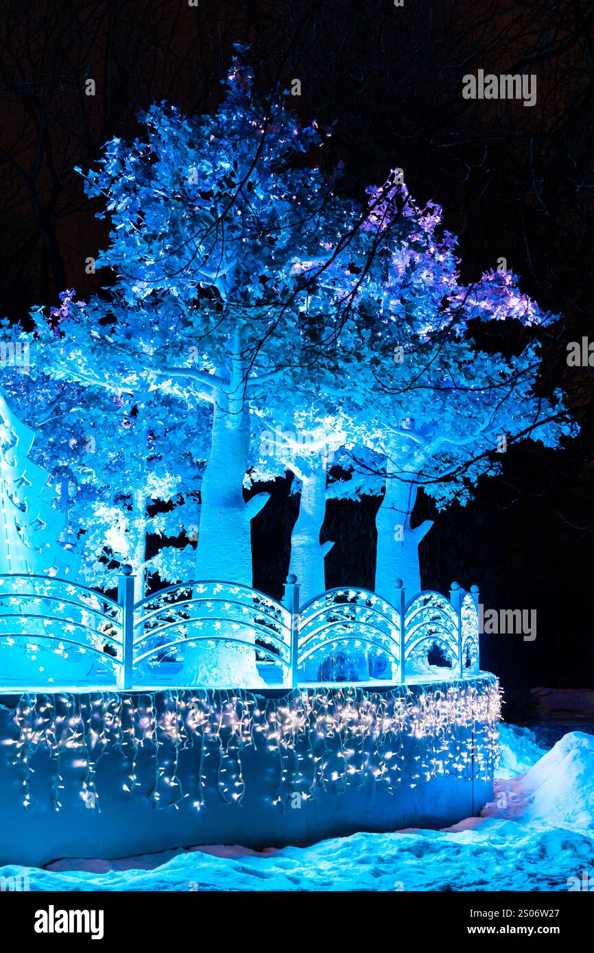 decorative trees with blue backlight in winter park. park decoration ...