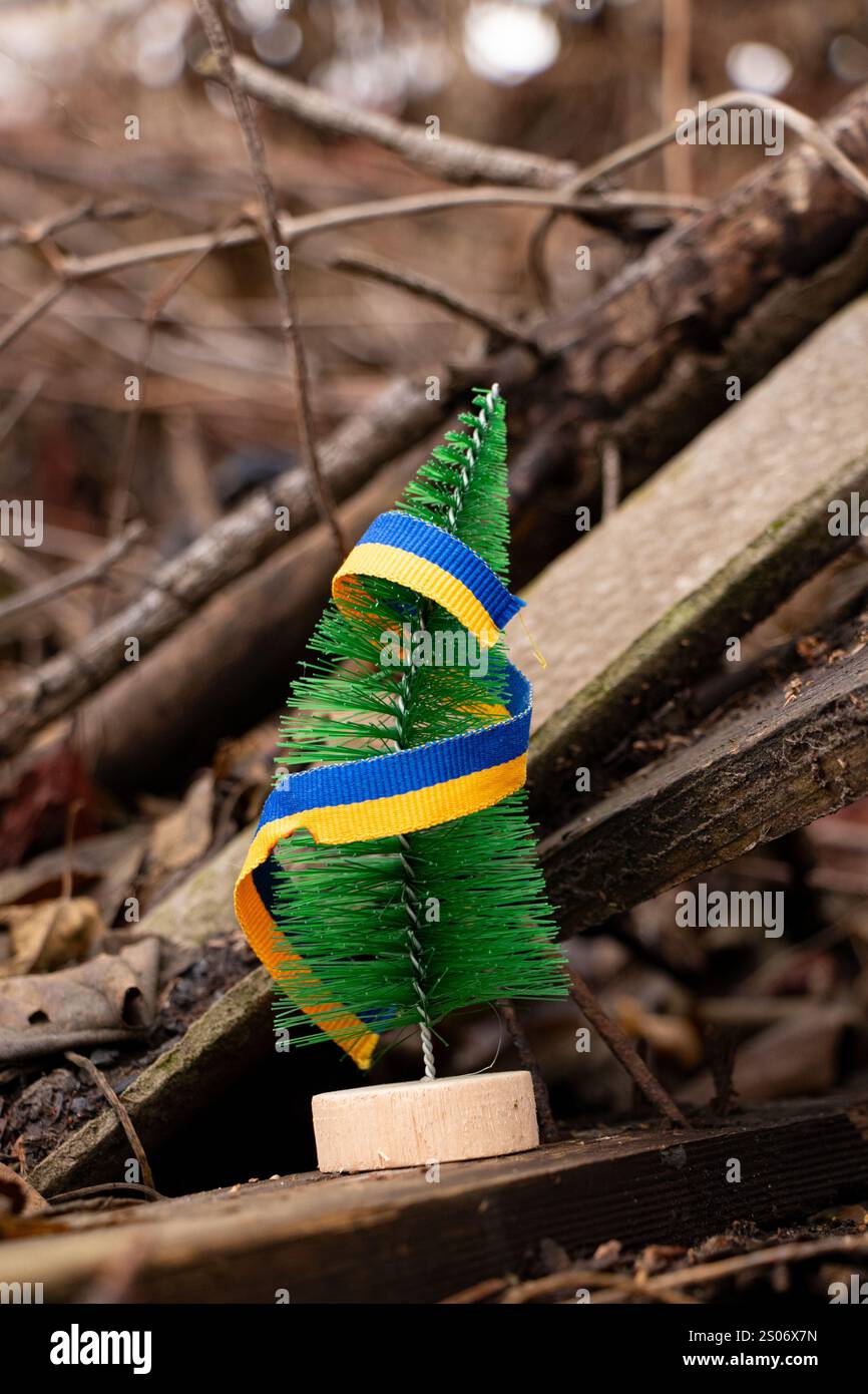 A small Christmas tree decorated with a ribbon of the Ukrainian flag ...