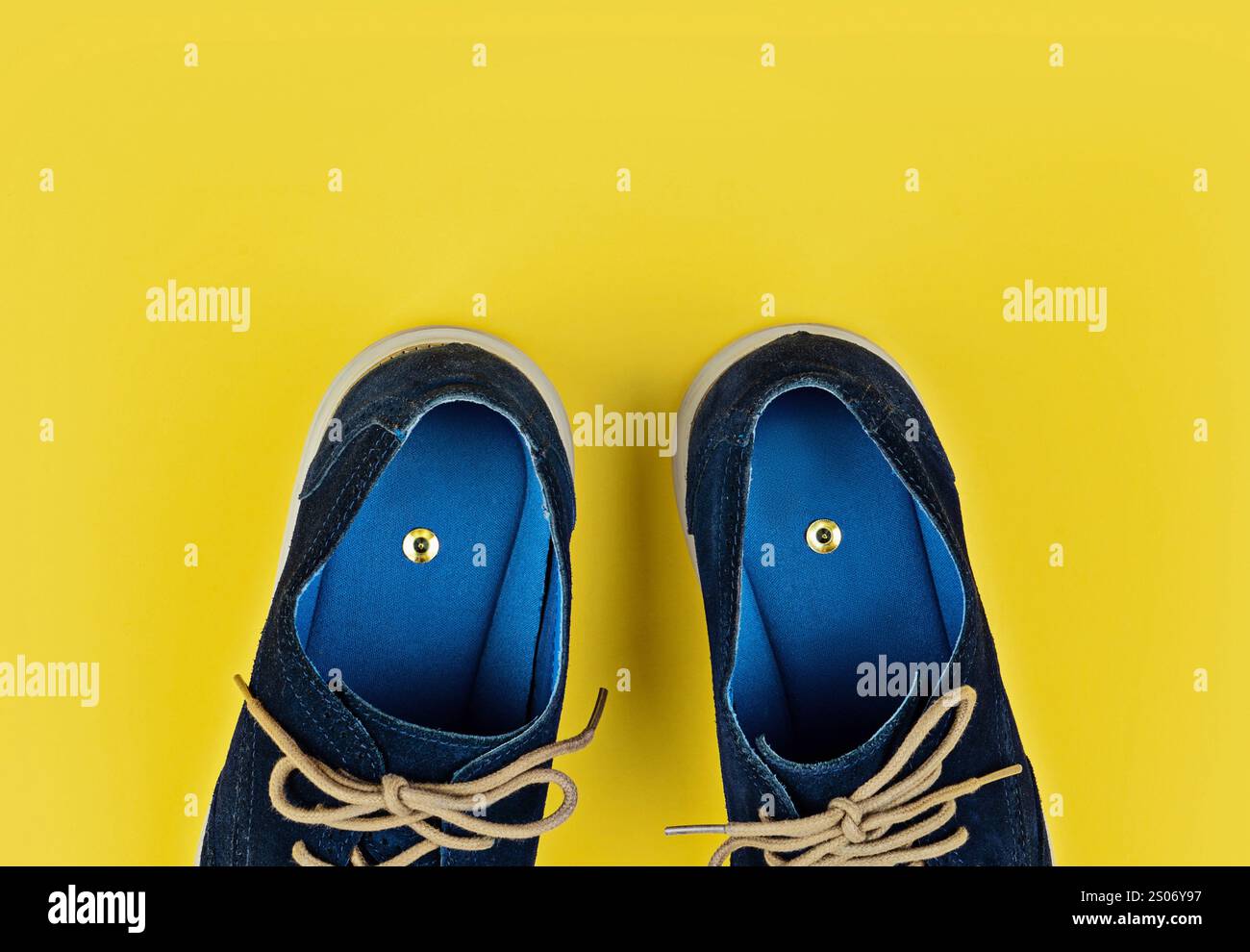 Blue Shoes With Push Pins Inside on Yellow Background With Copy Space ...