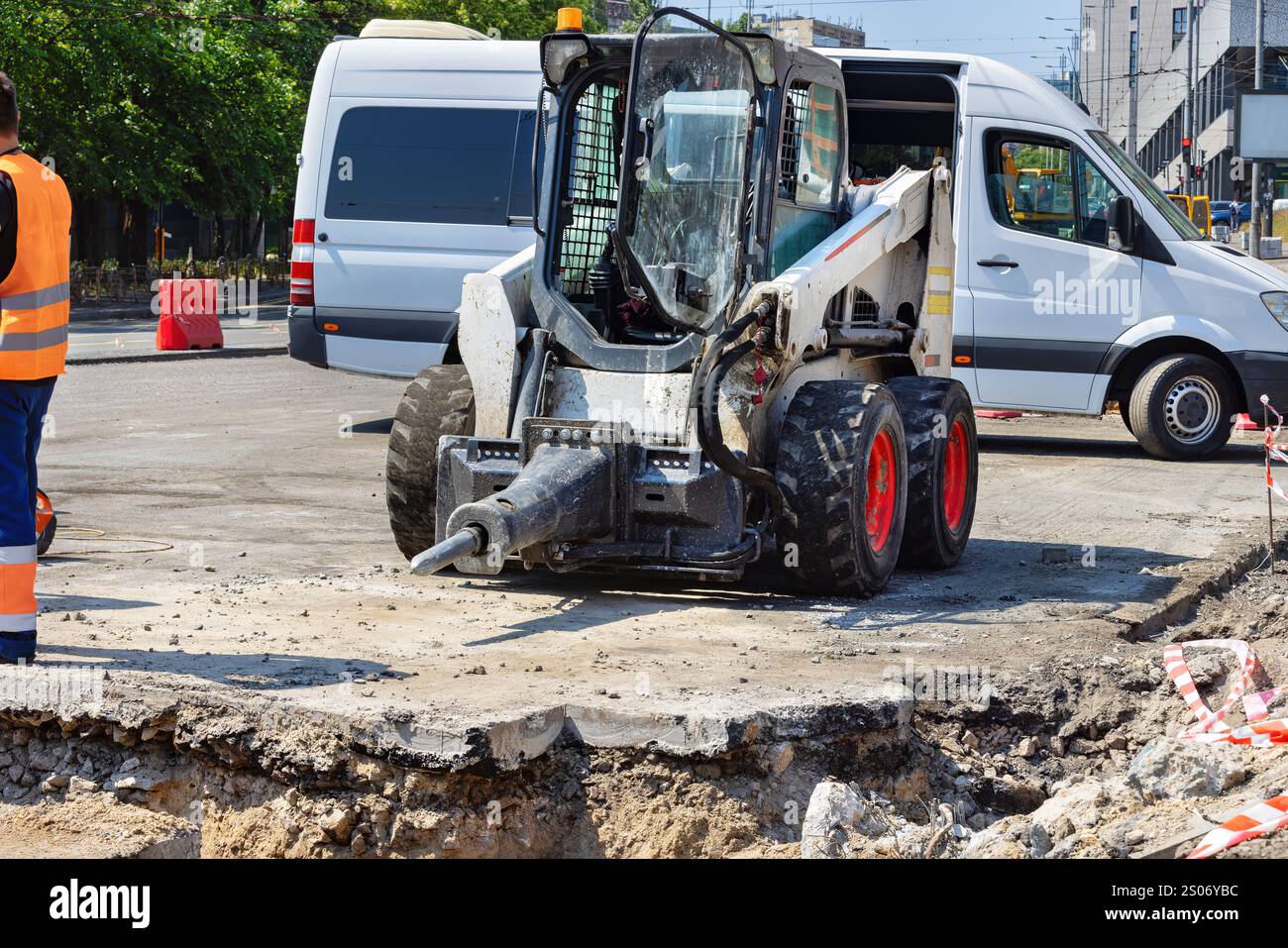 A construction vehicle diligently works on a city street, removing ...