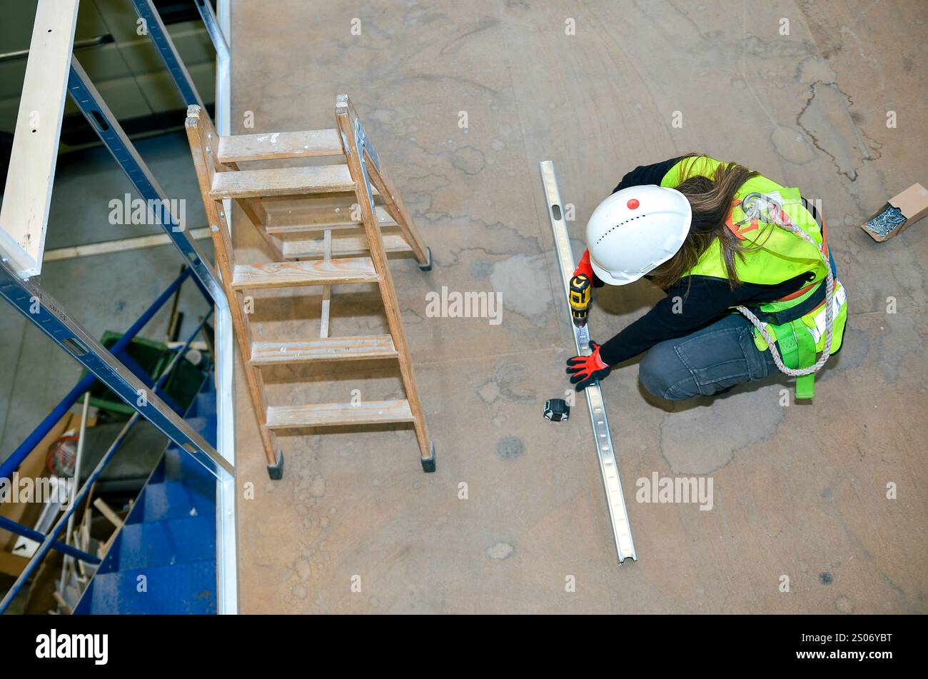 Female construction worker installing metal frame using spirit level ...