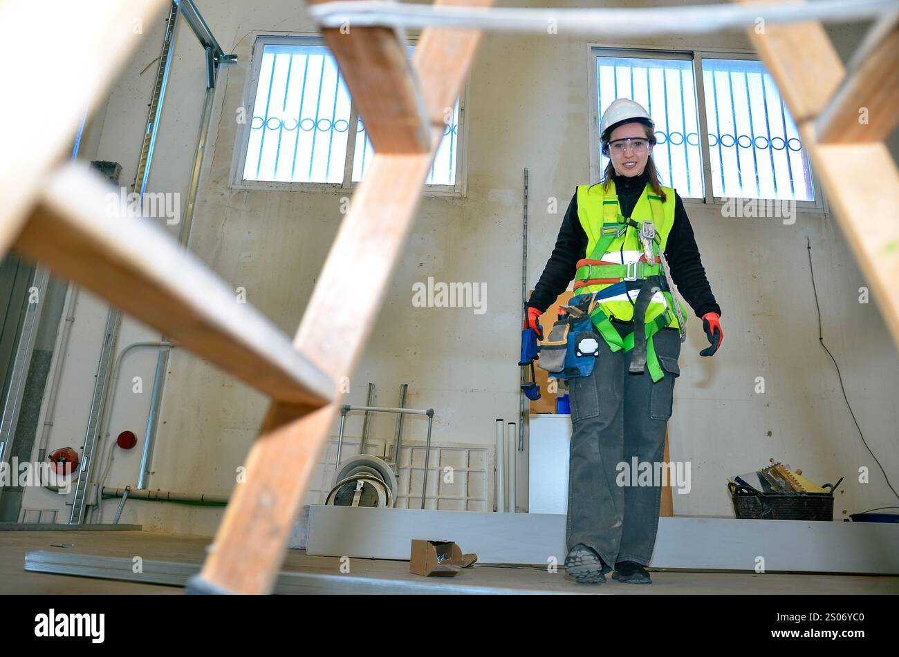 Female construction worker wearing safety equipment and holding tools ...