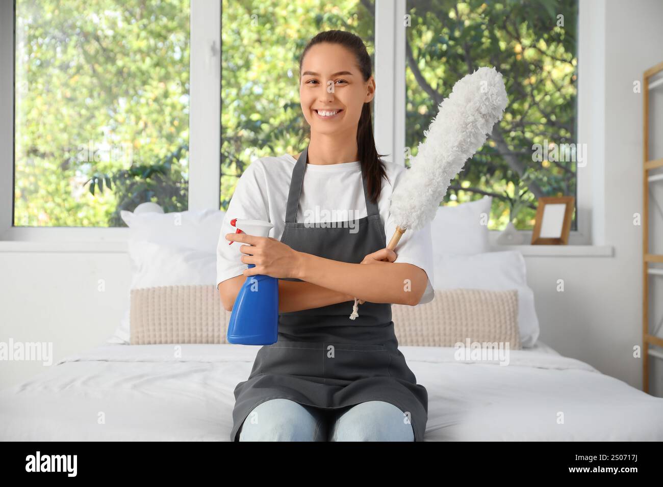 Female janitor with pp-duster and detergent sitting in bedroom Stock ...