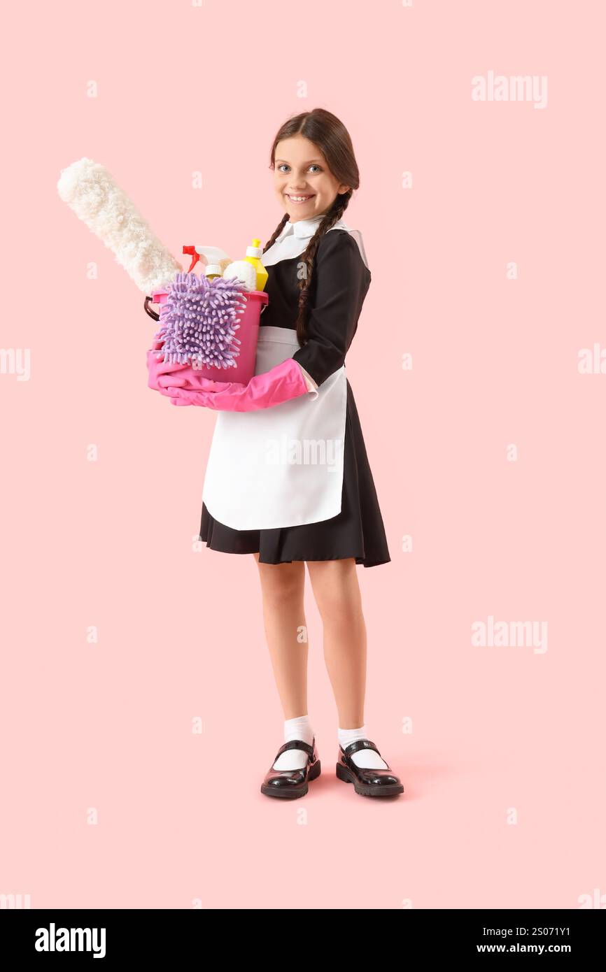 Cute chambermaid with cleaning supplies on pink background Stock Photo ...
