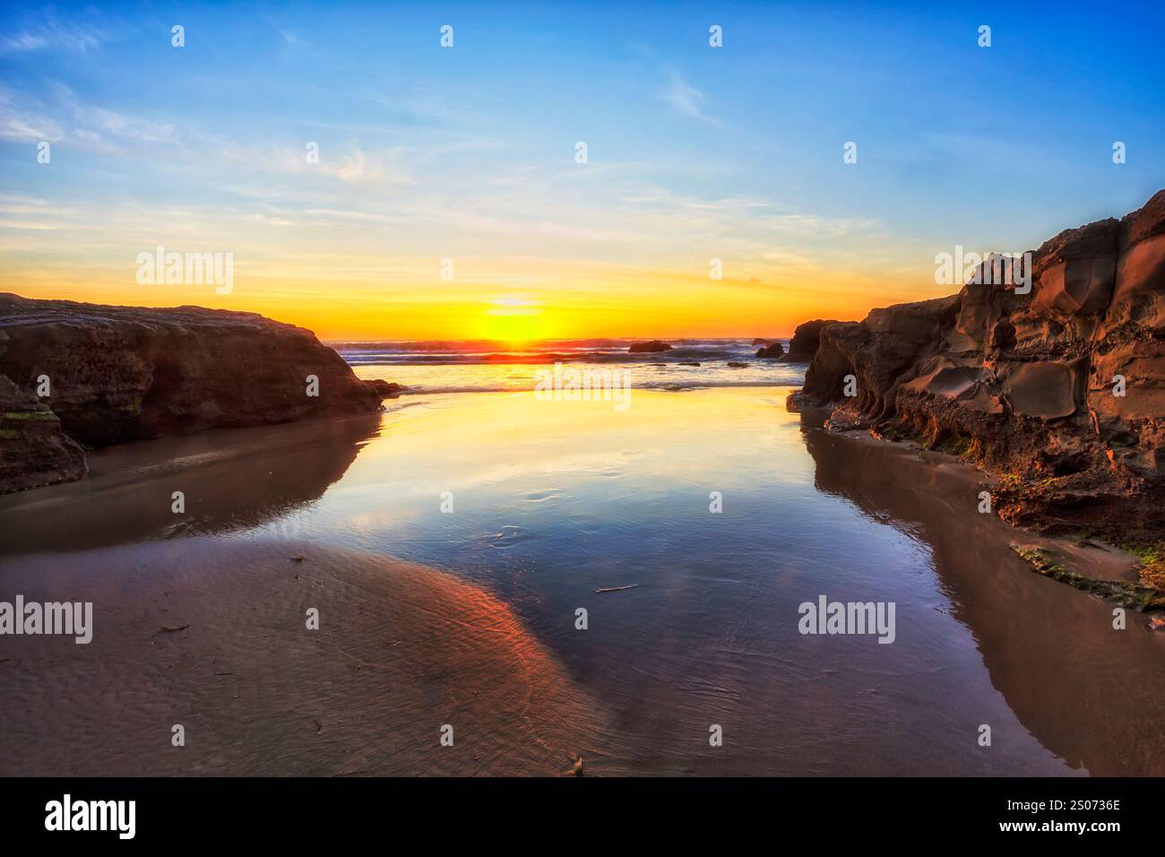 Scenic rising sun over Pacific ocean horizon off Caves beach in ...