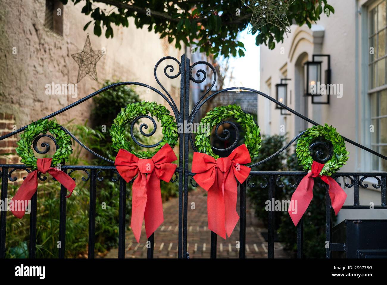 Christmas wreaths decorate a wrought iron gate made by master ...