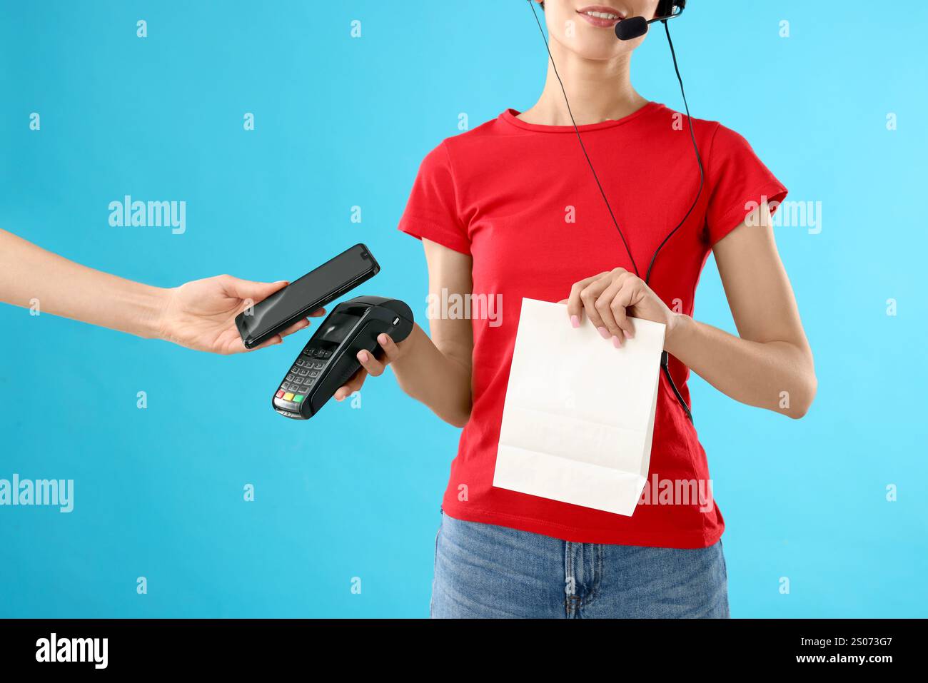 Fast-food worker taking payment from client via terminal on light blue ...