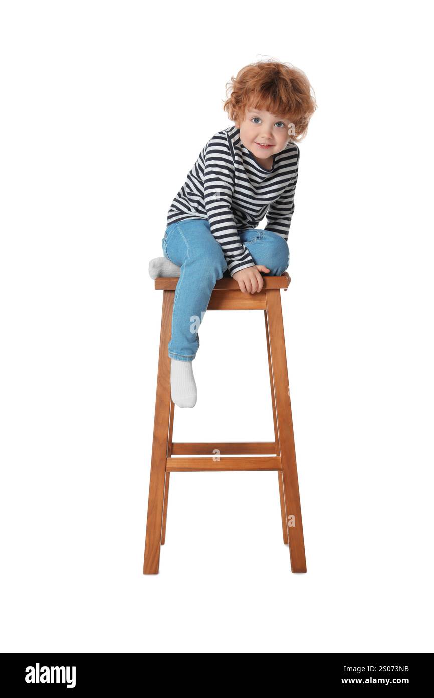 Little boy sitting on stool against white background Stock Photo - Alamy