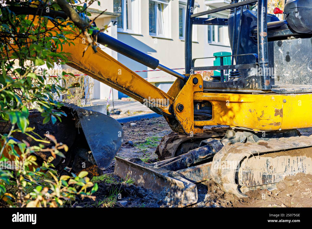 Part of a small crawler excavator standing in front of the house in the ...