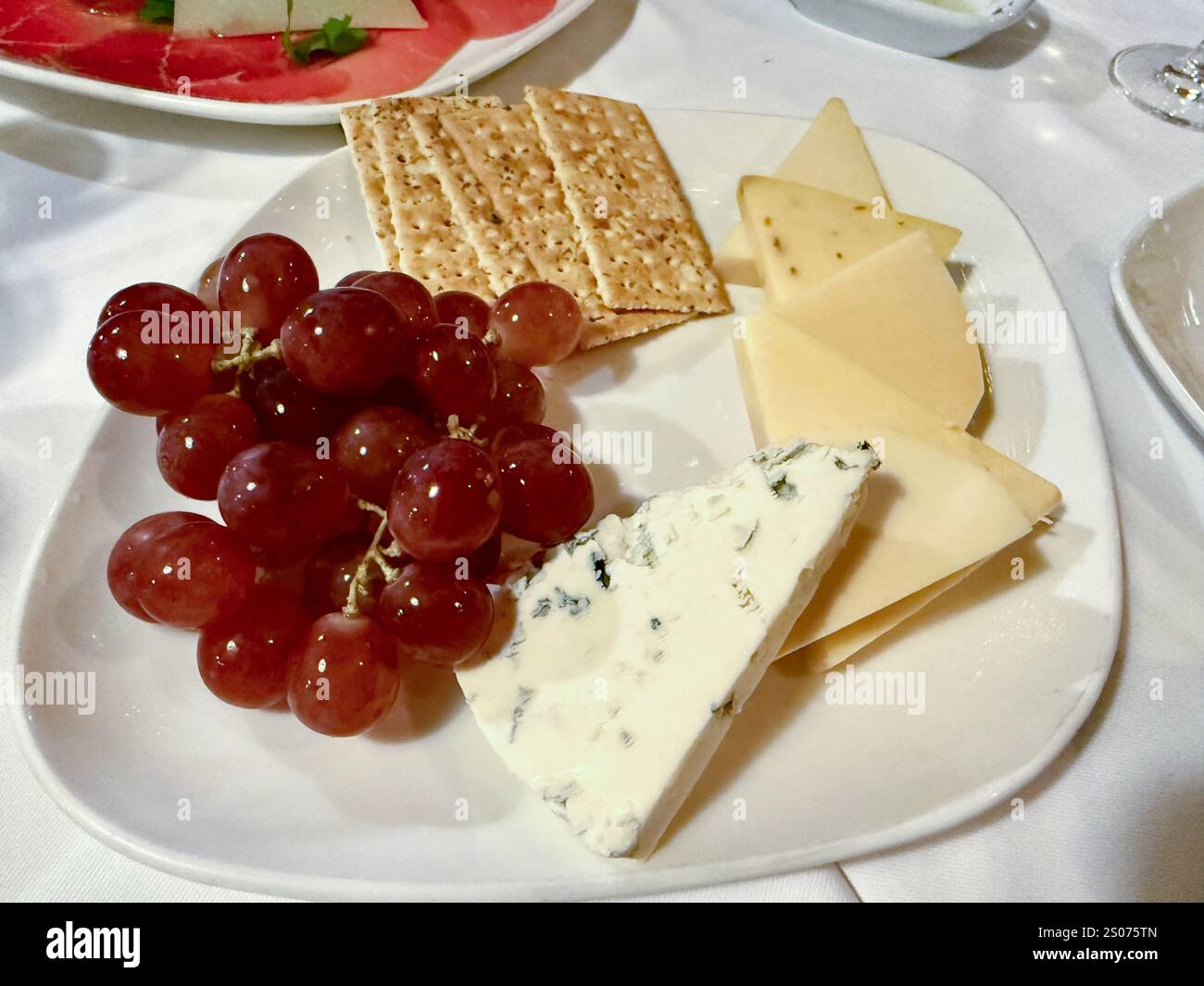 cheese appetizer on a plate with purple grape, cheese plate of ...
